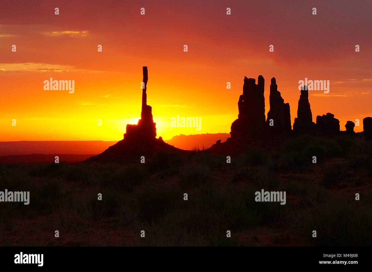 Sunrise at the iconic Monument Valley. The sun rises behind totem pole ...