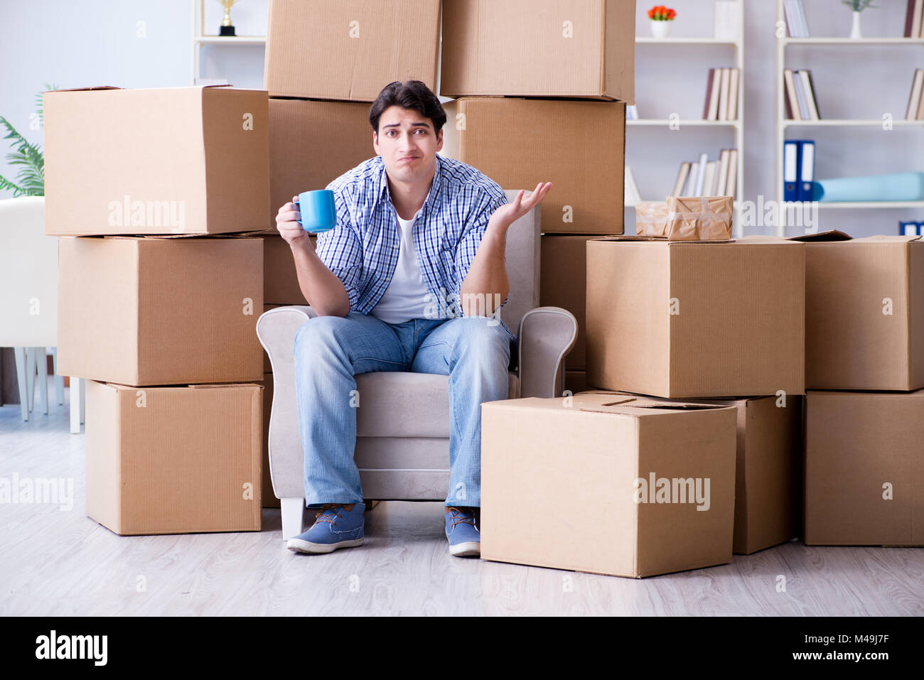 Young man moving in to new house with boxes Stock Photo - Alamy