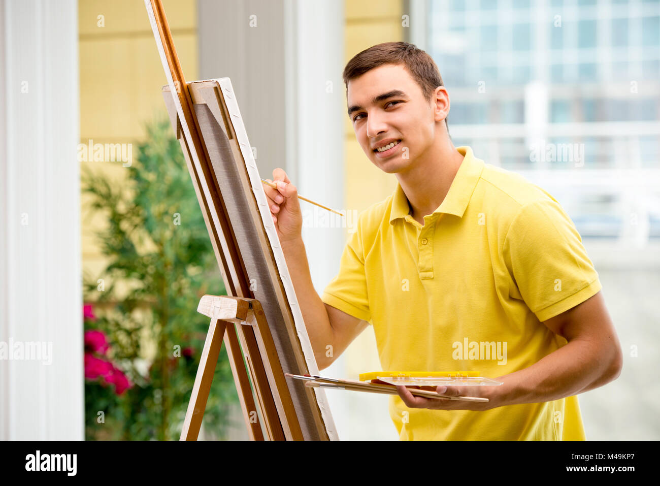 Young male artist drawing pictures in bright studio Stock Photo - Alamy