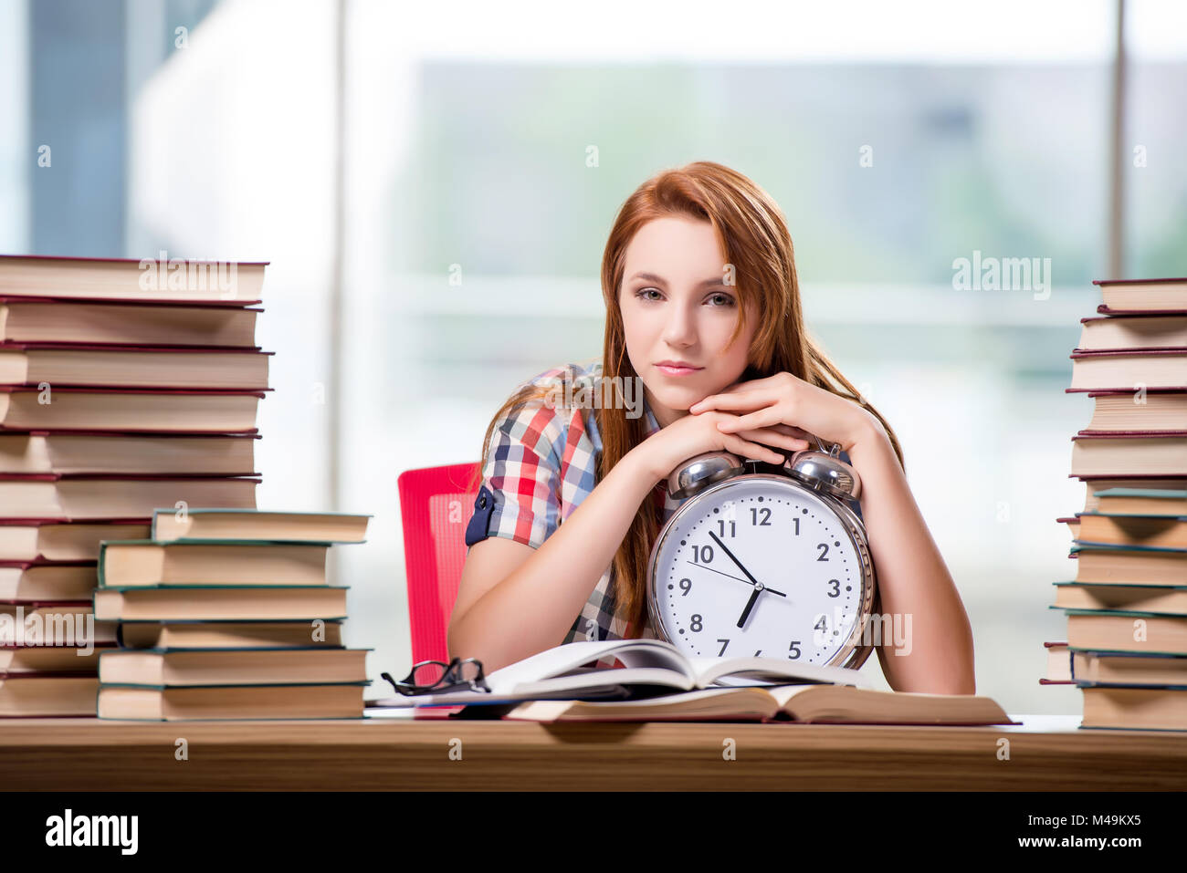 Female student with clock preparing for exams Stock Photo - Alamy