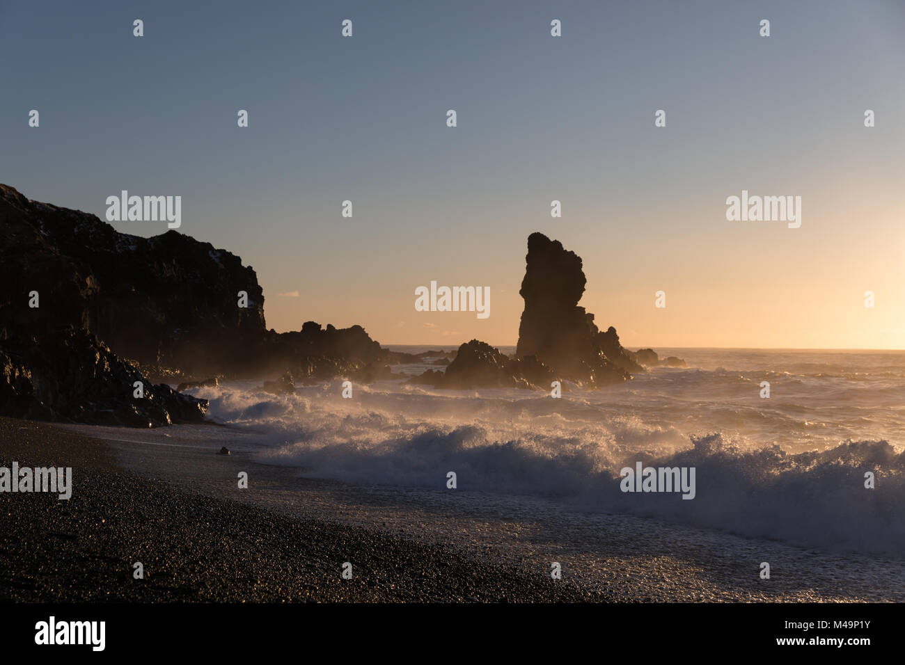 Atlantic Ocean waves crash against the black sand/pebble ...