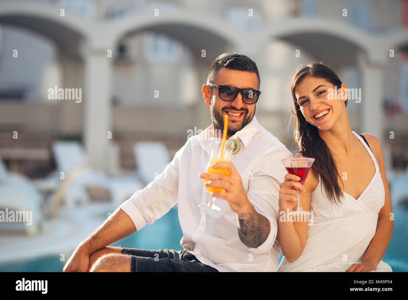Loving couple spending vacation on tropical resort swimming pool ...