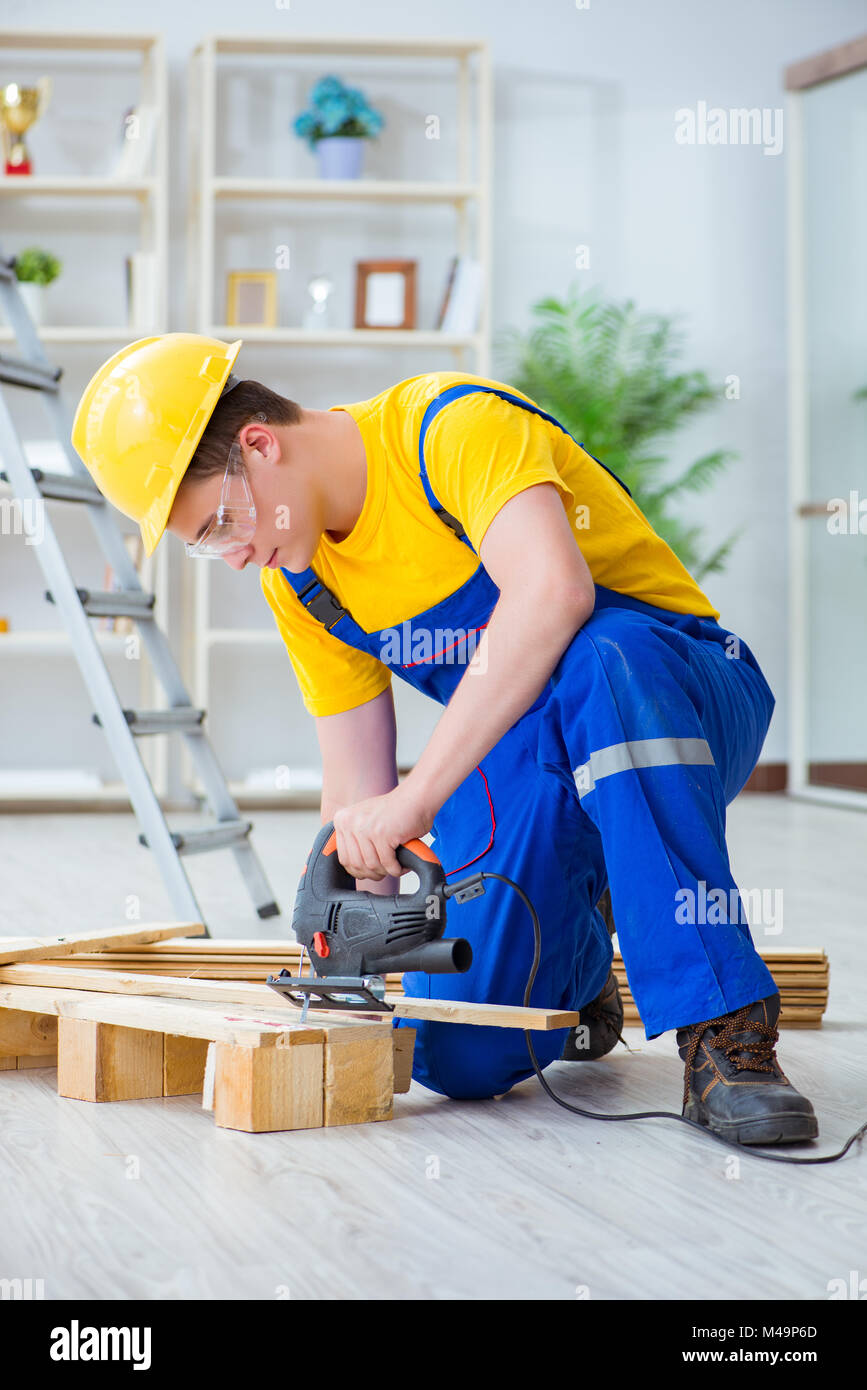 Young man assembling wood pallet Stock Photo - Alamy