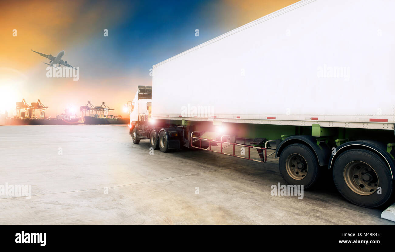 container truck in shipping port and cargo plane flying above Stock ...