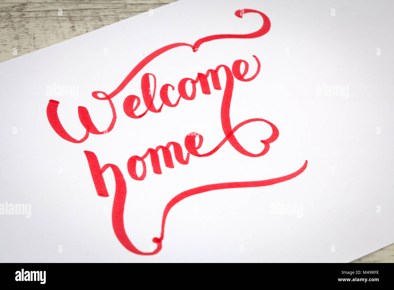 Welcome Home creative brush lettering in red color Stock Photo - Alamy