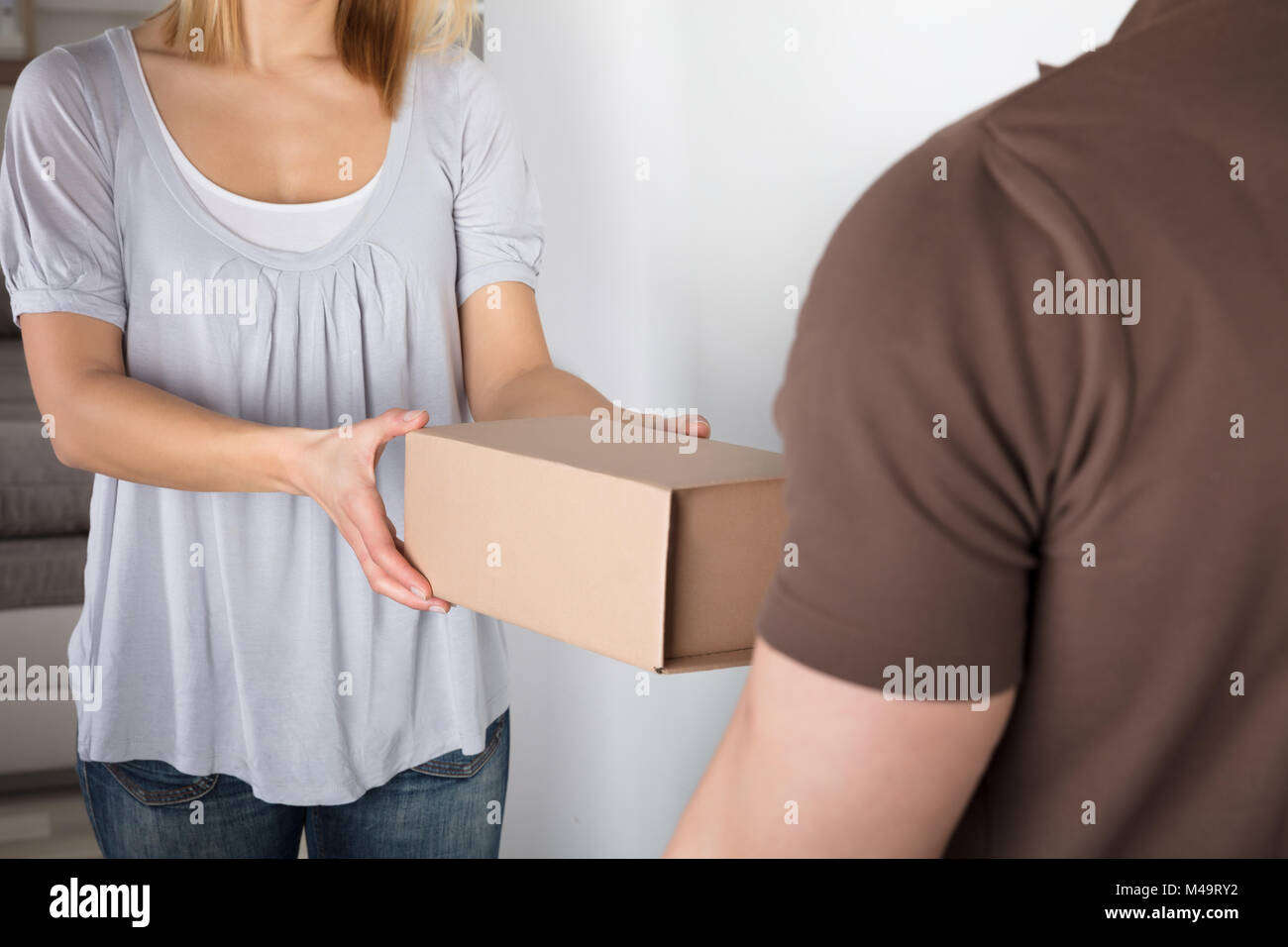 Close-up Of Woman Taking Cardboard Box From Delivery Man Stock Photo ...