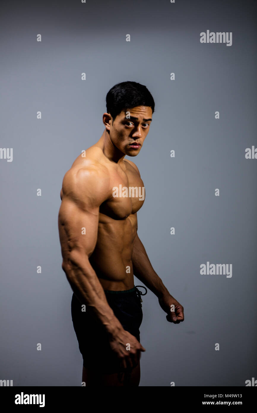 An Asian fitness model poses for the camera. Medium shot. Profile Stock ...