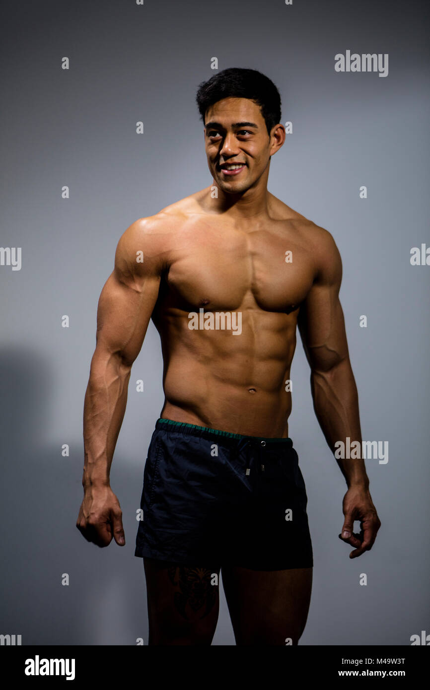 An Asian fitness model poses for the camera smirking. Medium shot Stock ...