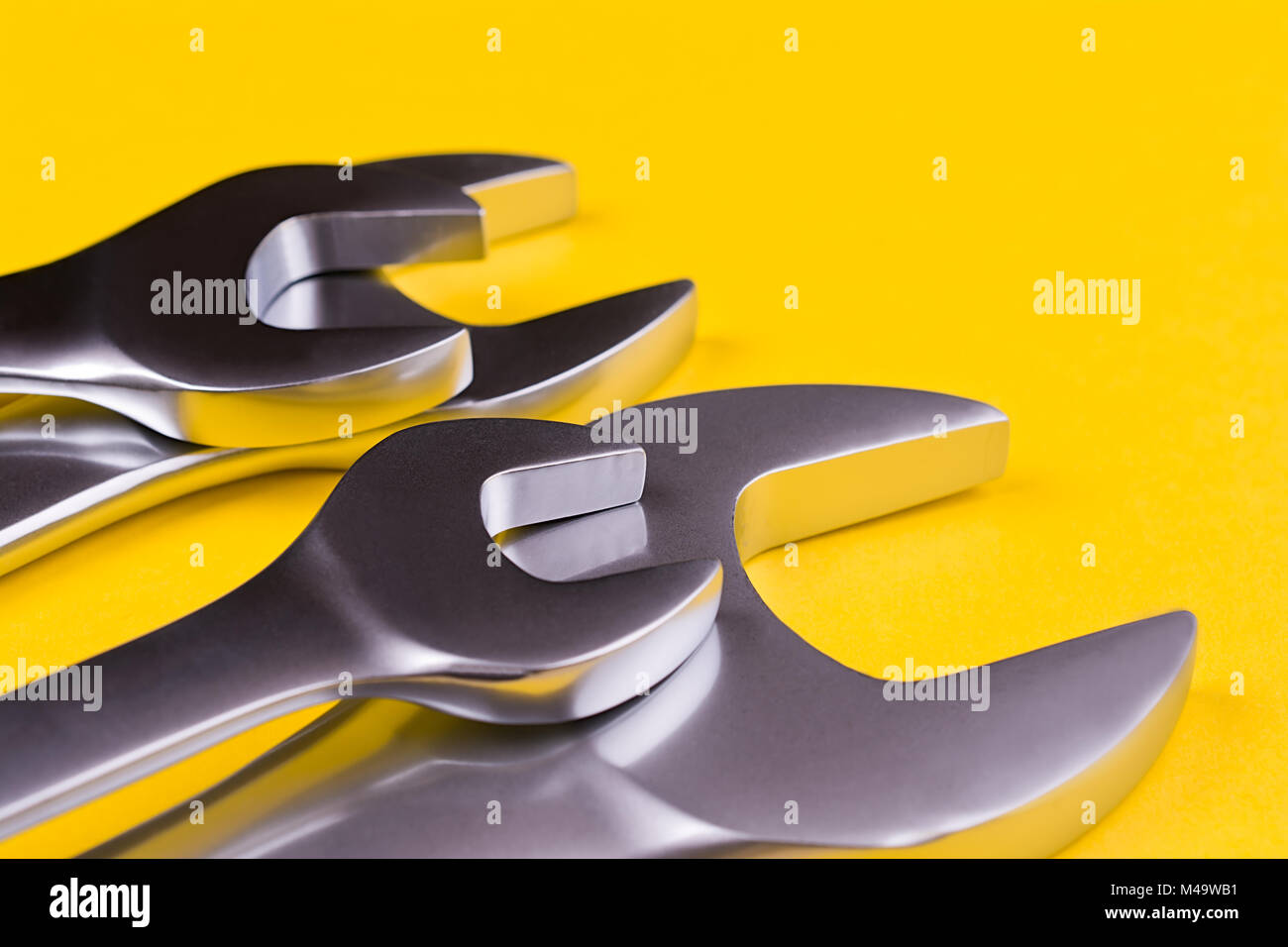Spanners of various sizes, on yellow background Stock Photo - Alamy