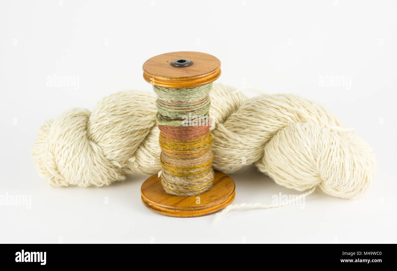 Hank of hand spun wool and a bobbin on a white background Stock Photo ...