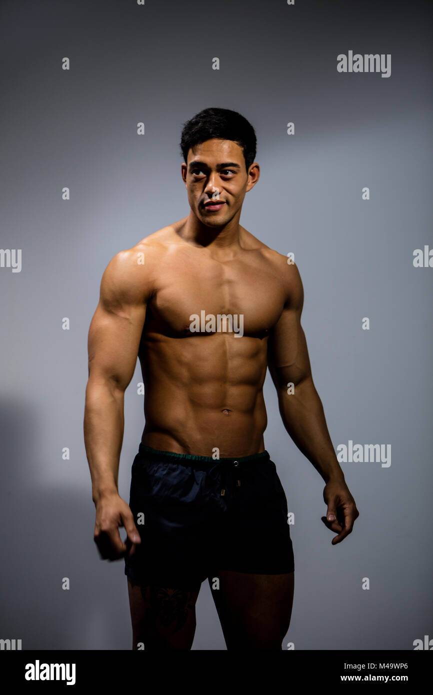 An Asian fitness model poses for the camera smirking. Medium shot Stock ...