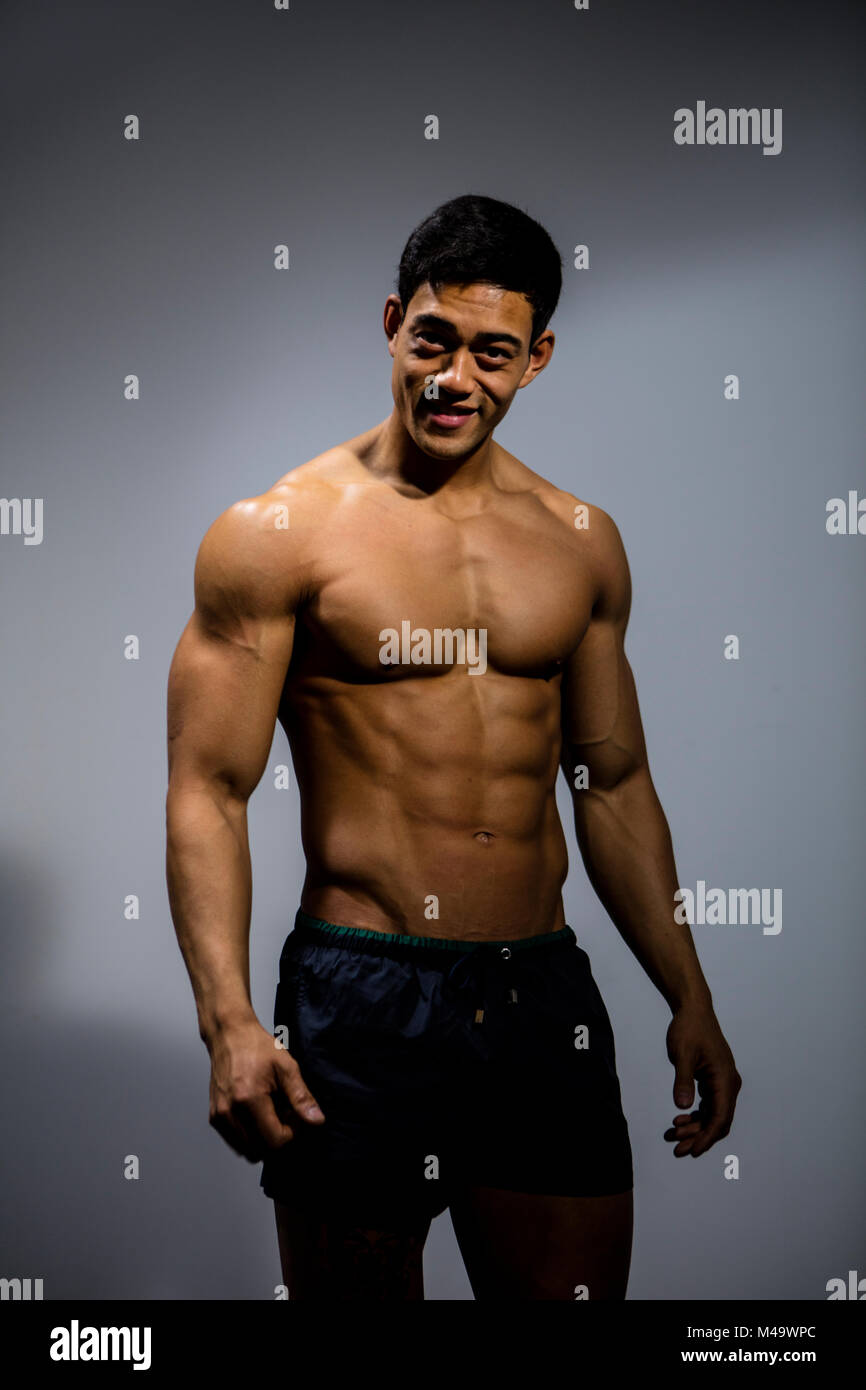 An Asian fitness model poses for the camera smiling. Medium shot Stock ...