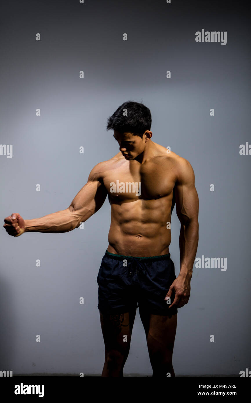 A fitness model flexes his bicep looking towards the muscle Stock Photo ...