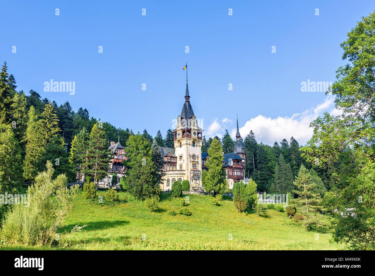 Daylight side far view to Peles castle front facade with hanging flag ...