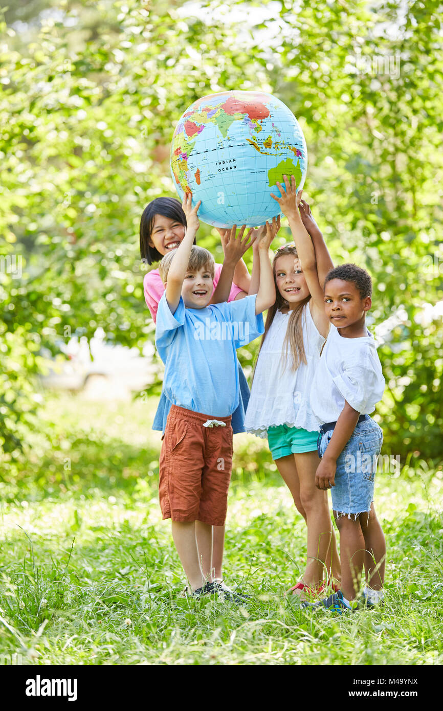 Multicultural group of children together holds up a world globe Stock ...