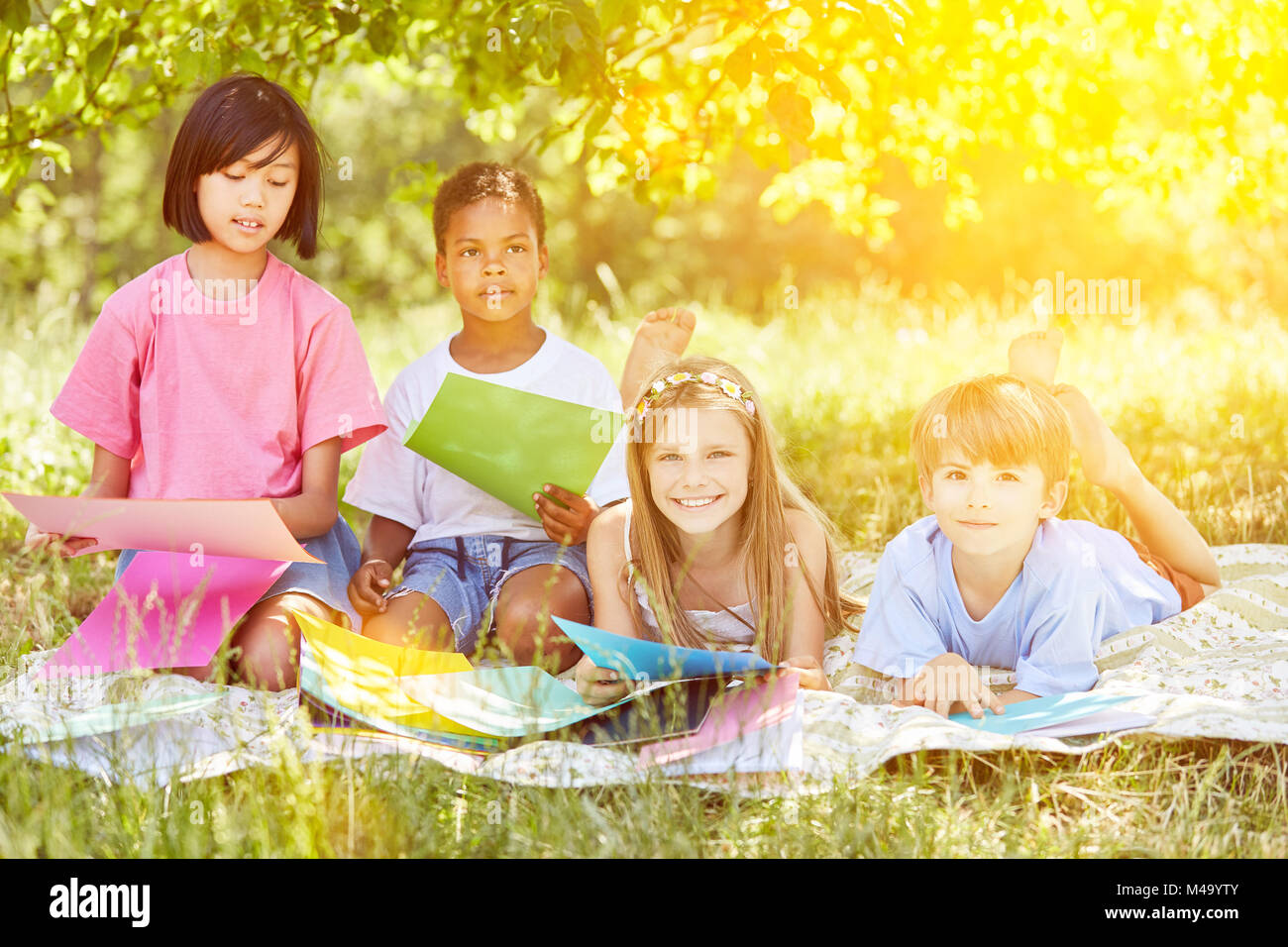 Group of kids playing and tinkering in the garden in summer on a ...