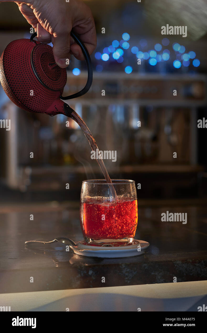 Barista making a red tea with a classic Italian coffee machine in ...