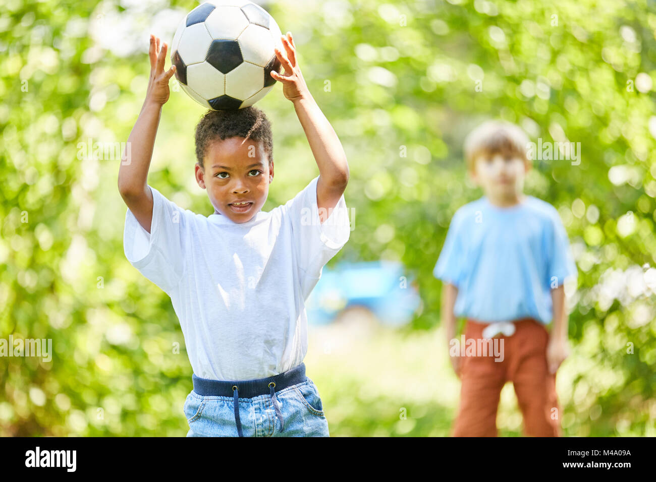 African boy is balancing a football on the head in nature Stock Photo ...
