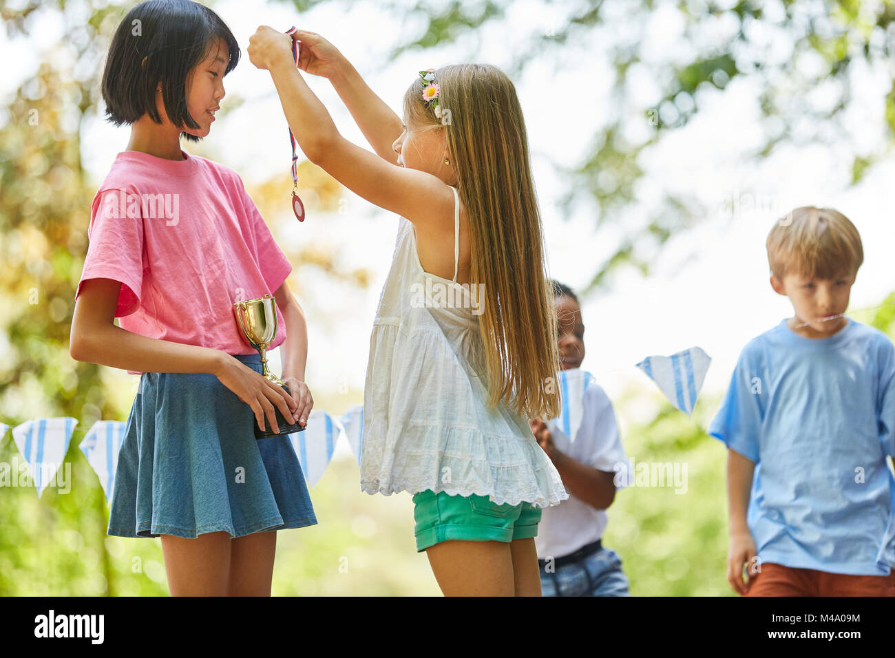 Girl gives the winner a medal in kindergarten Stock Photo - Alamy