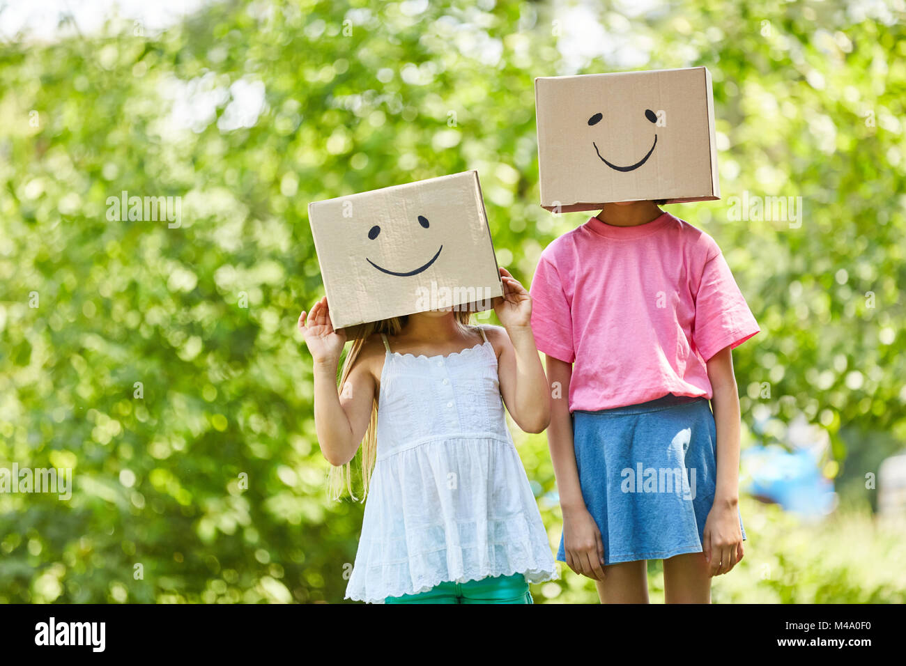 Two children hide their faces under funny painted cardboard boxes Stock ... Two children hide their faces under funny painted cardboard boxes Stock ...