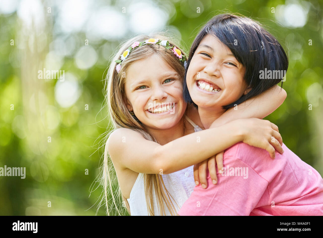 Two Girls As Girlfriends Hug Each Other Happily In The Summer In The