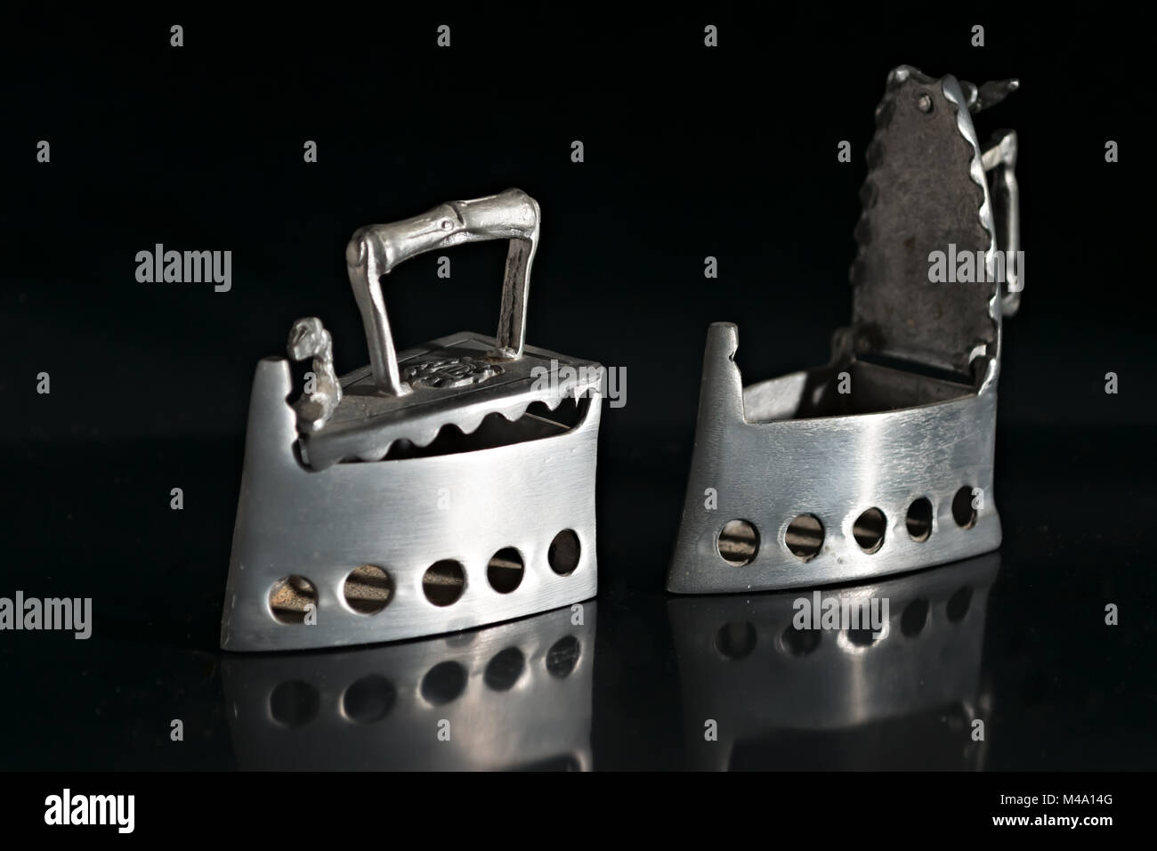 two retro style miniature irons on black Stock Photo - Alamy