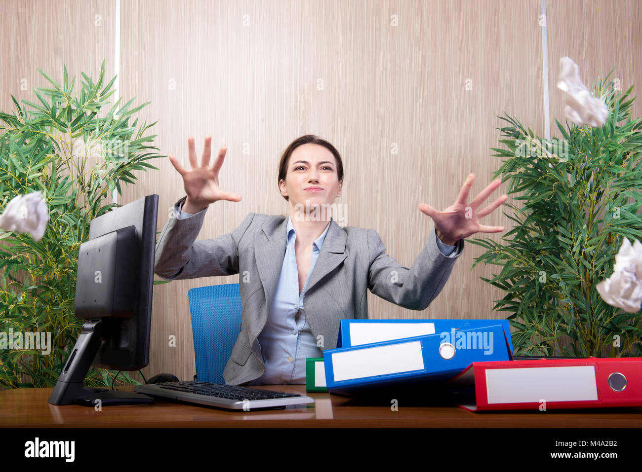 Woman under stress tossing papers in the office Stock Photo - Alamy