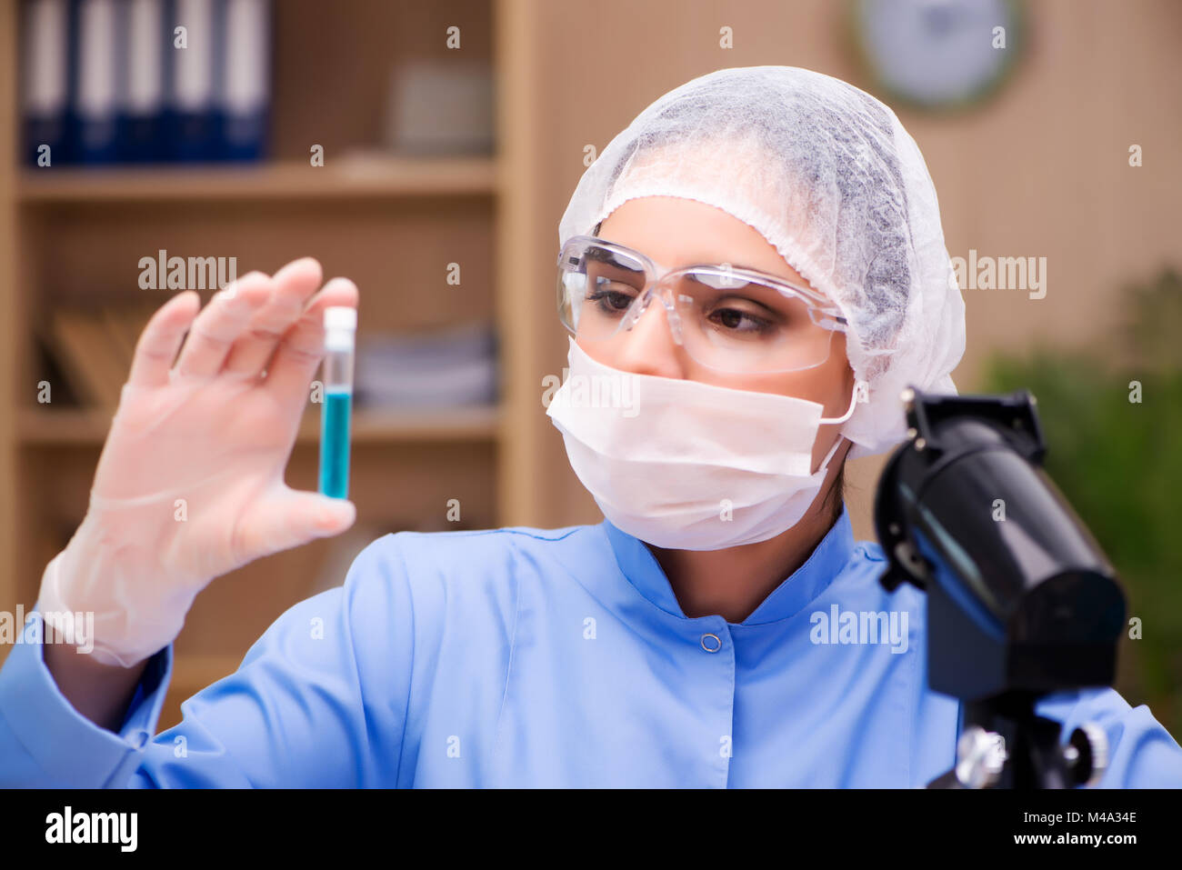 Lab chemist working with microscope and tubes Stock Photo - Alamy