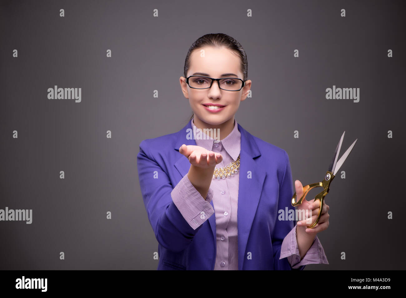 Young woman with scissors against gray background Stock Photo - Alamy