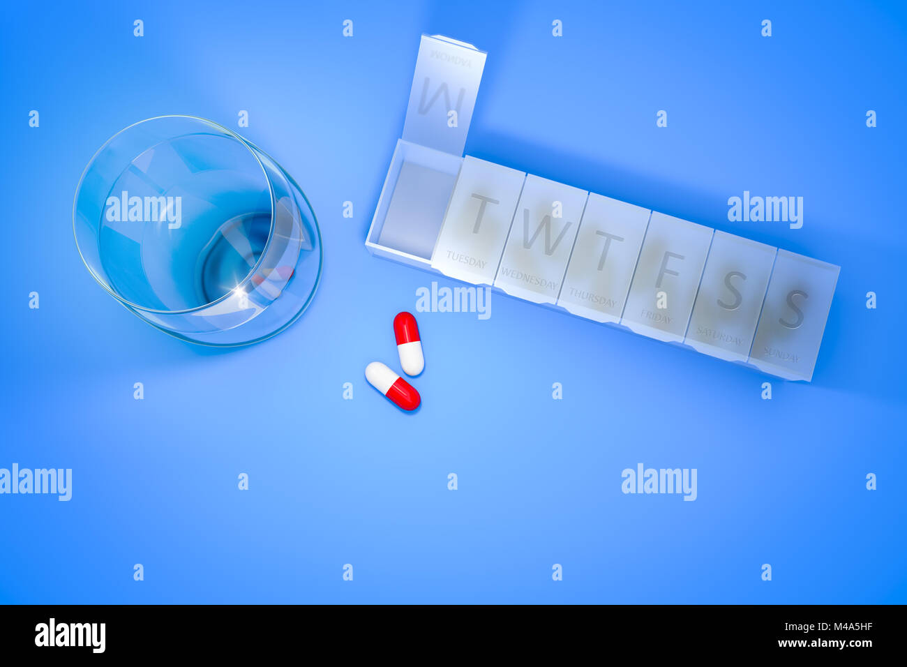 reminder box for pills and a glass of water Stock Photo - Alamy
