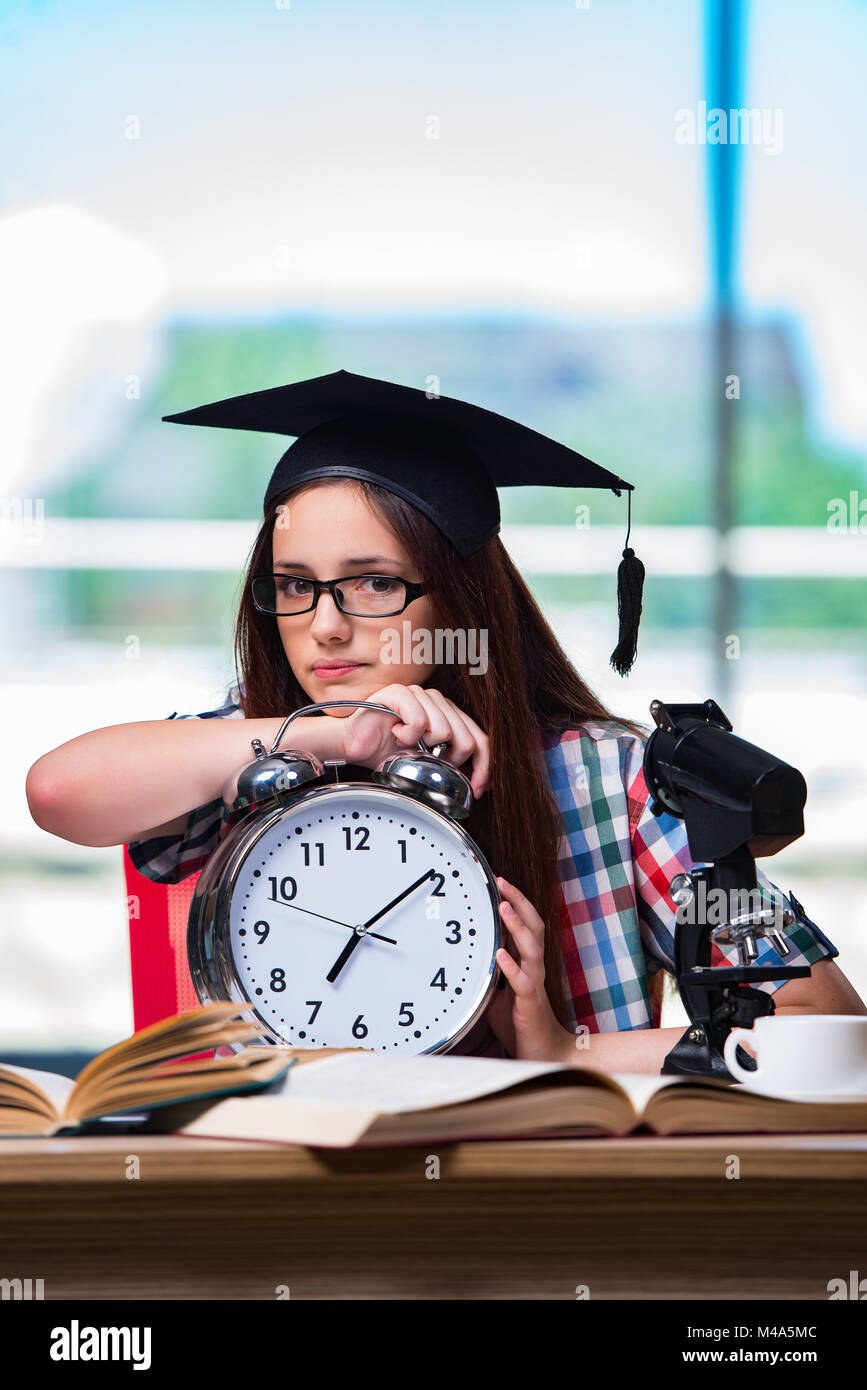Young girl preparing for exams with large clock Stock Photo - Alamy