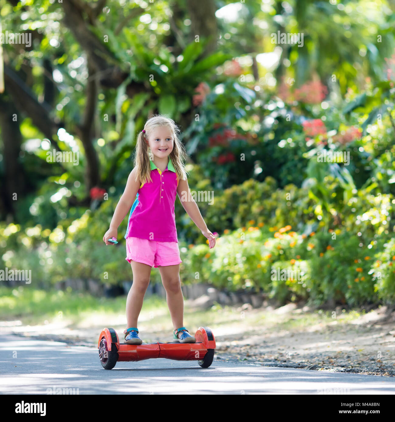 Child on hover board. Kids riding scooter in summer park. Balance board ...