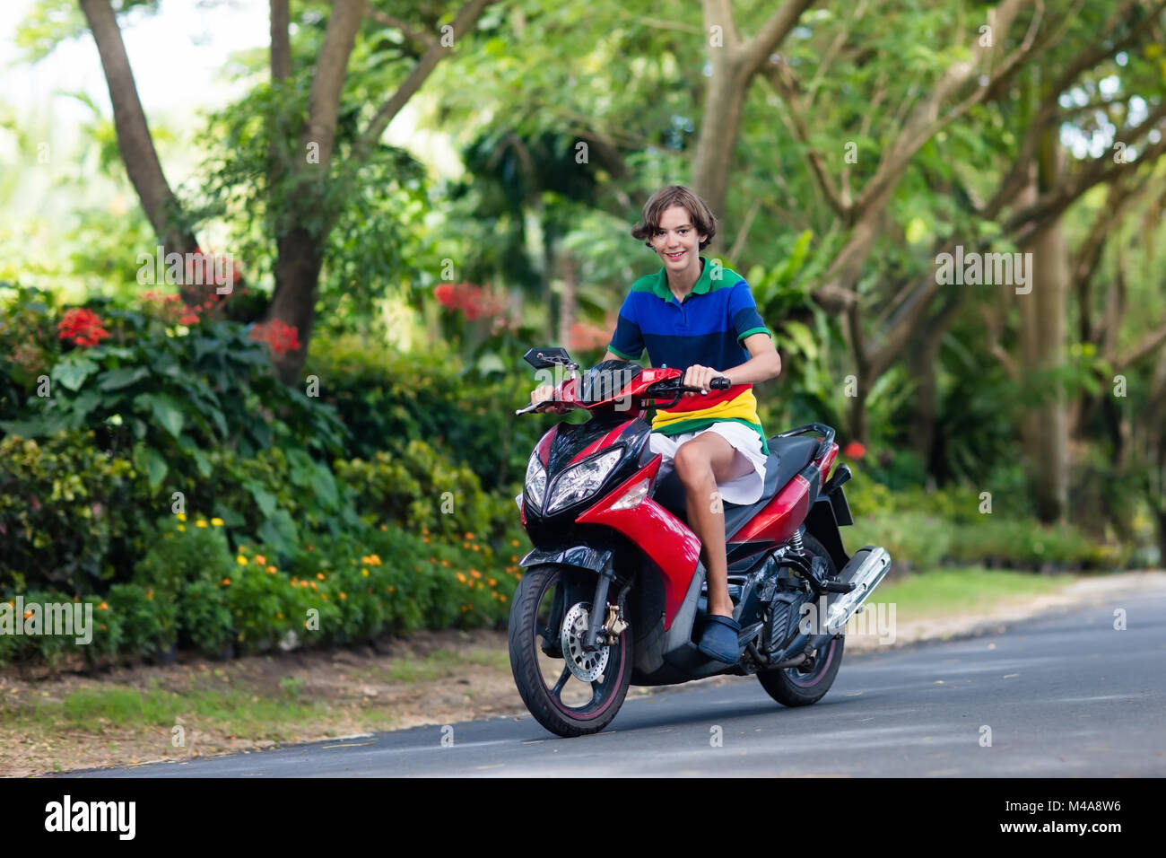 Teenager riding scooter. Teenage boy fun on motorbike ride on his way ...
