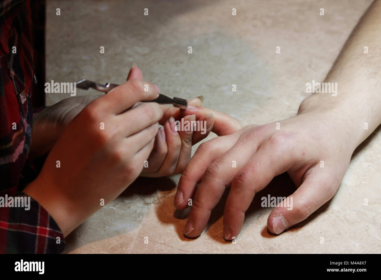 A student at the training courses of a manicure gives shape to nails ...