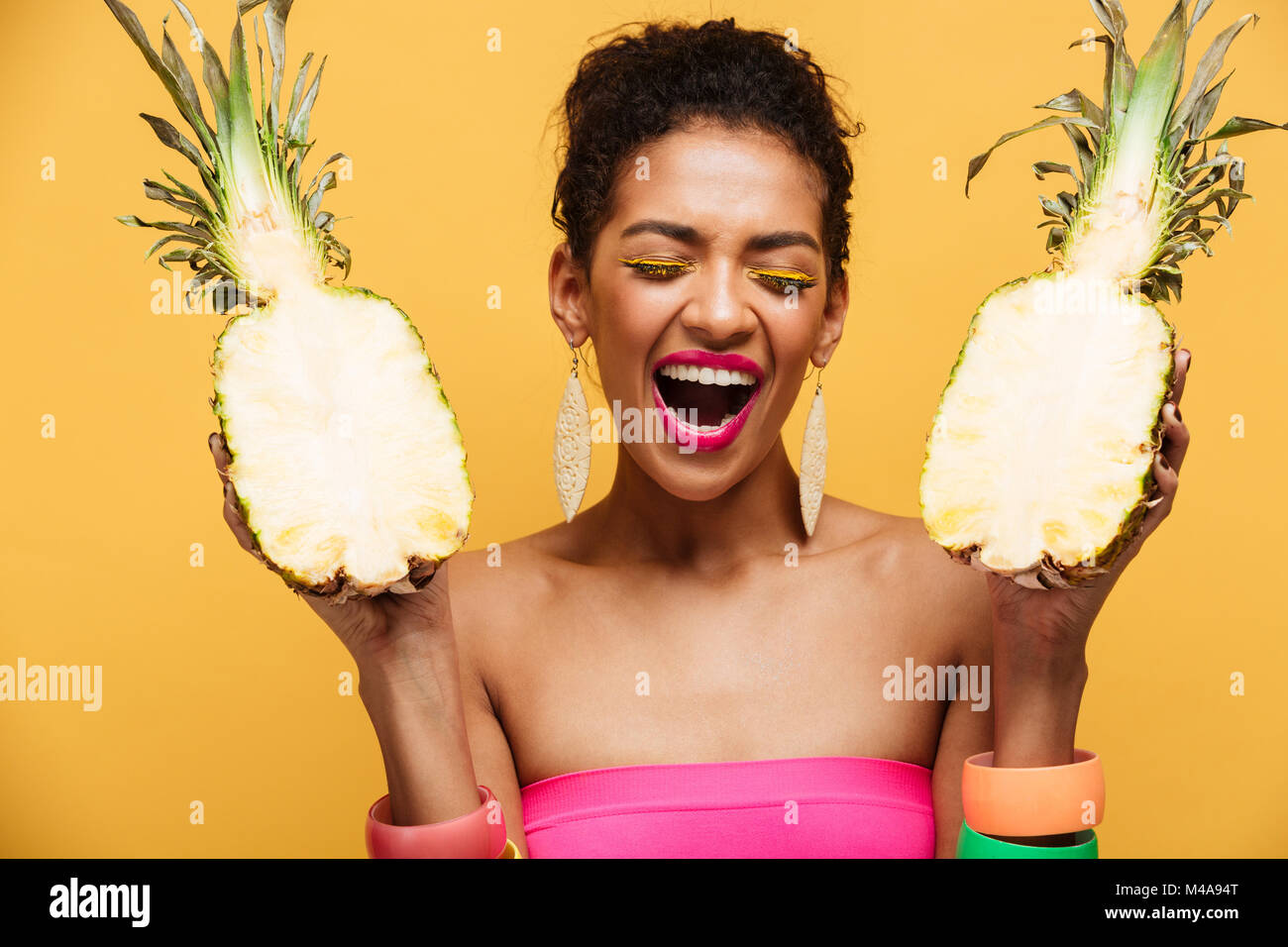 Ecstatic young woman with afro hairstyle and colorful makeup holding ...