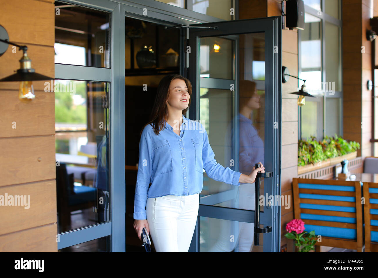 Cheerful woman leaving restaurant, talking by smartphone and loo Stock ...