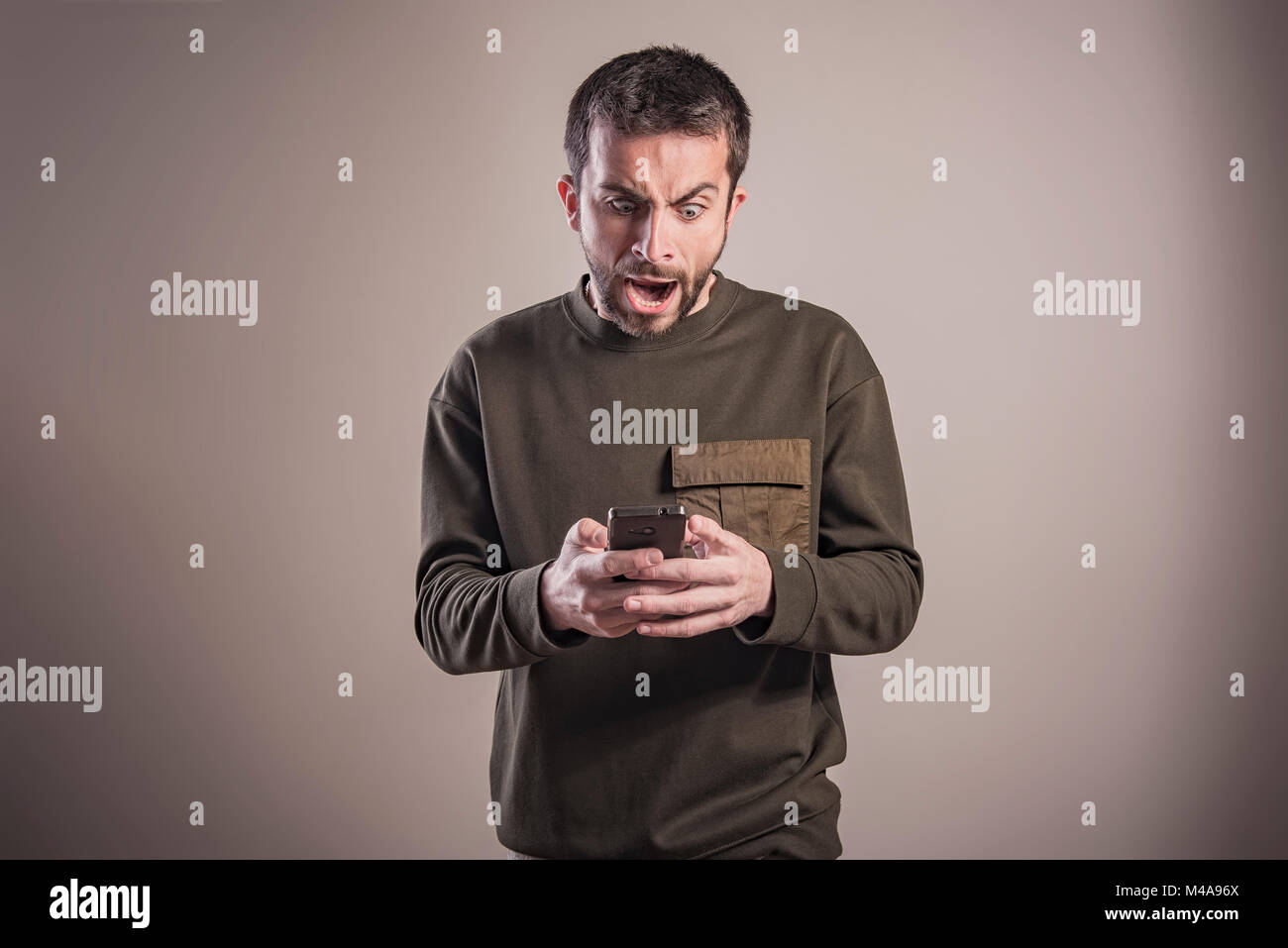 Man angry at his phone, outraged and enraged Stock Photo - Alamy