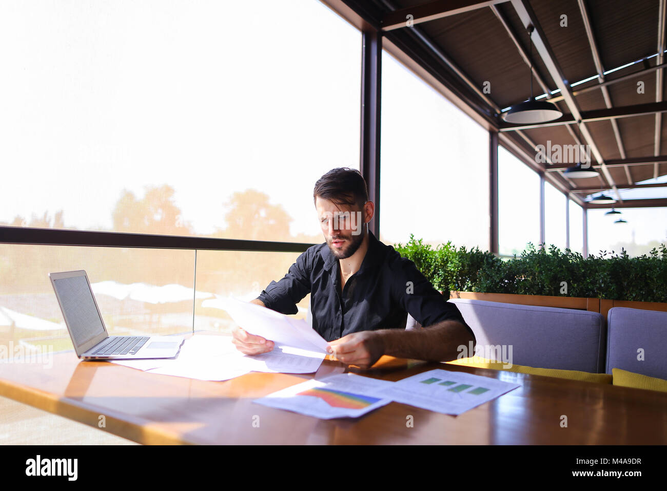 Office worker sorting papers on table near laptop Stock Photo - Alamy