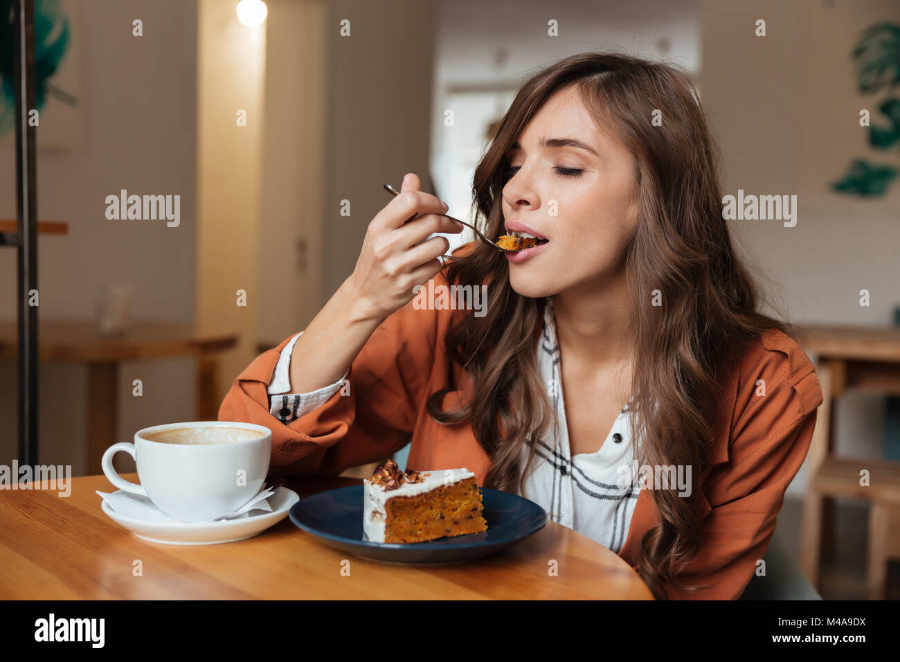 Portrait Of A Satisfied Woman Eating A Piece Of Cake And Drinking