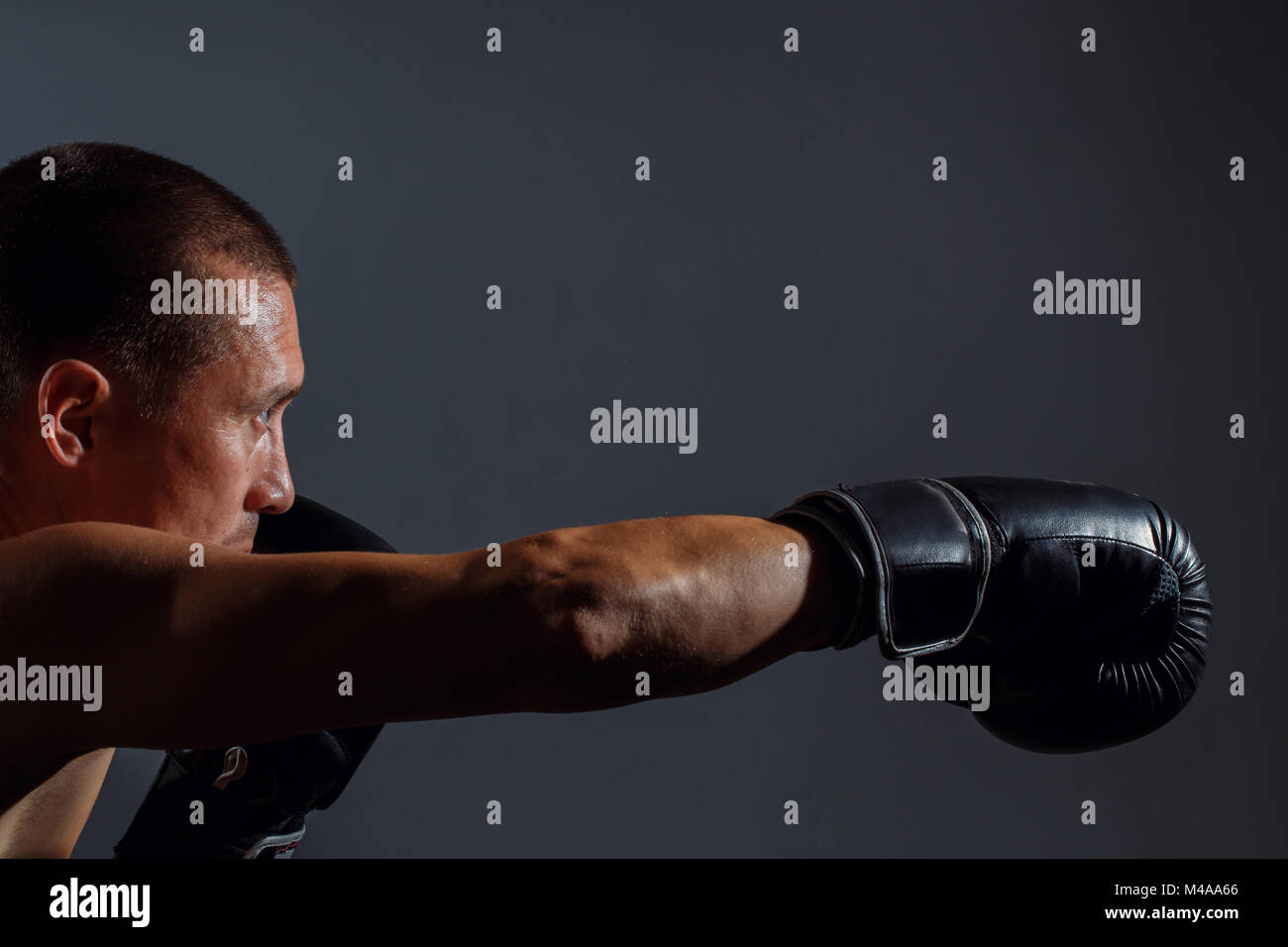 Sporty man during boxing exercise making direct hit Stock Photo - Alamy