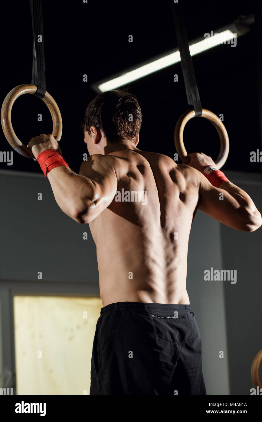 tree attractive young male and female adults doing pull ups on bar in ...