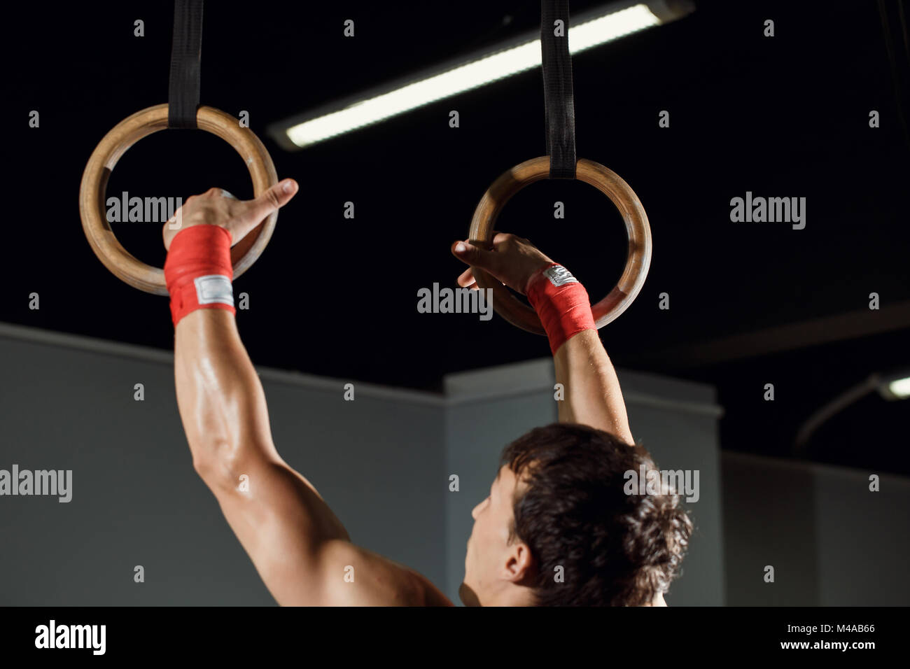 tree attractive young male and female adults doing pull ups on bar in ...