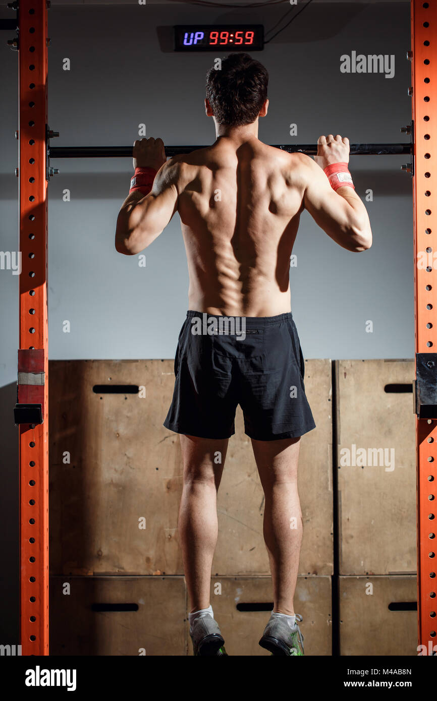 Fitness toes to bar man pull-ups bars workout exercise at gym Stock ...