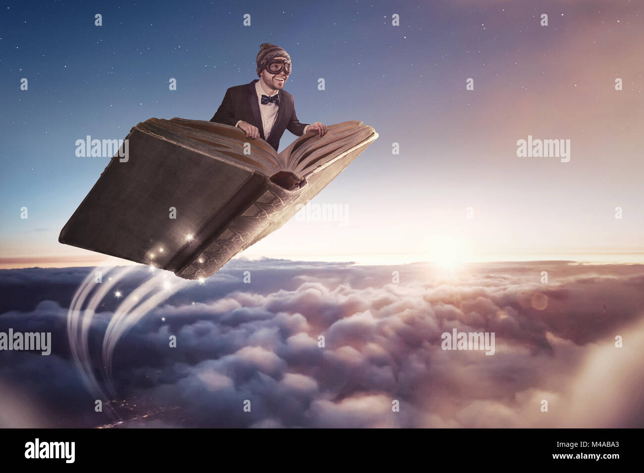 Flying book over the clouds Stock Photo - Alamy