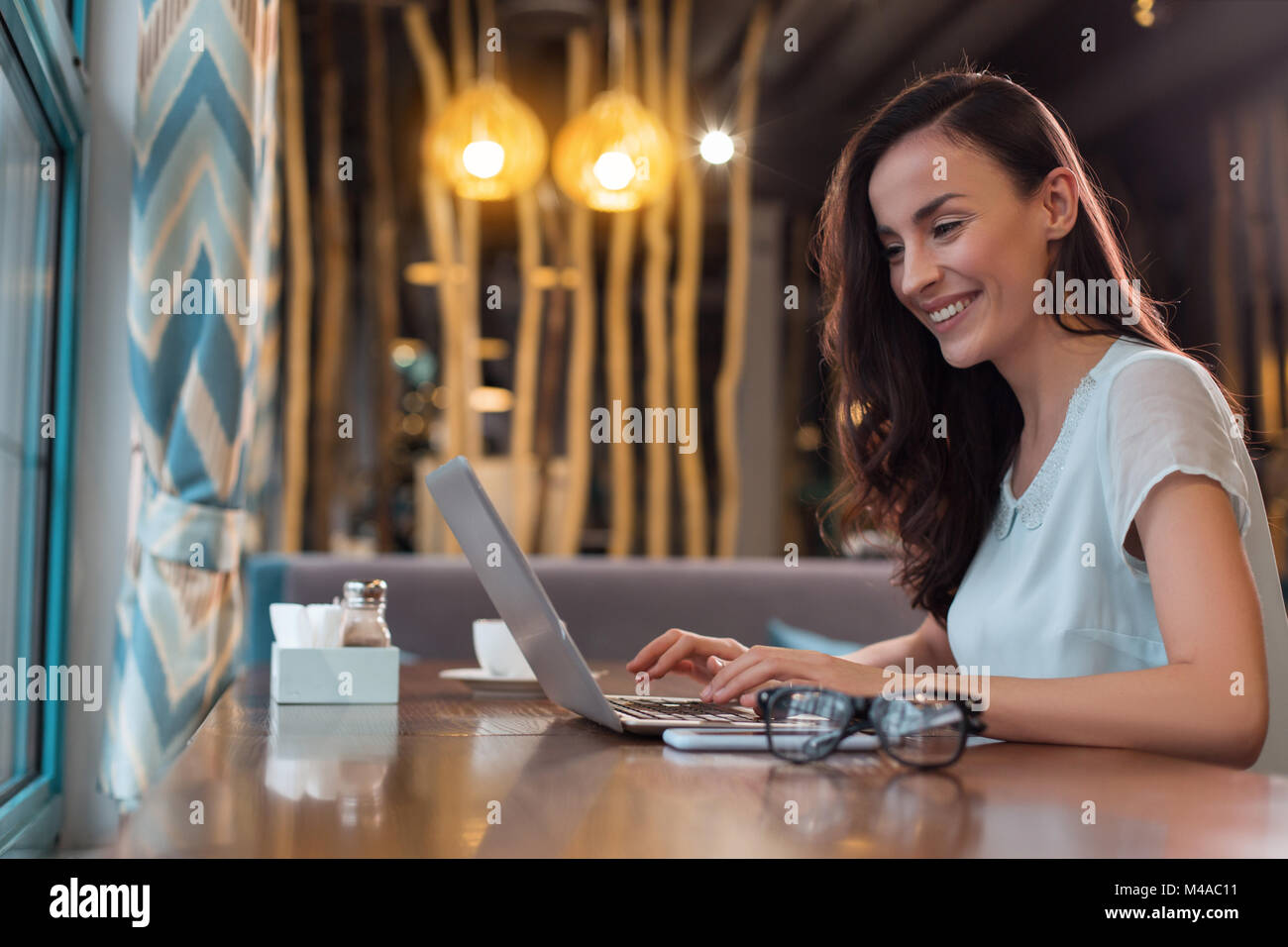 Pleasant female freelancer finishing work Stock Photo - Alamy