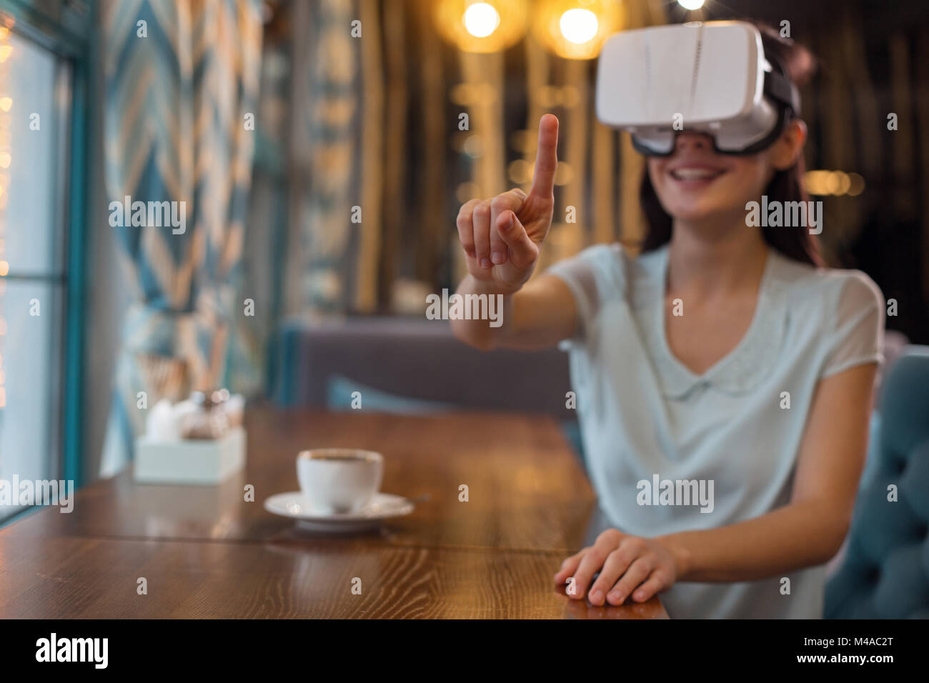 Enthusiastic energetic woman trying to touch VR object Stock Photo - Alamy