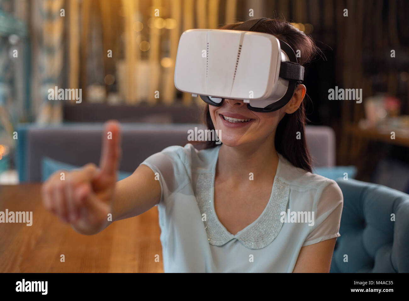 Beautiful positive woman using VR glasses Stock Photo - Alamy