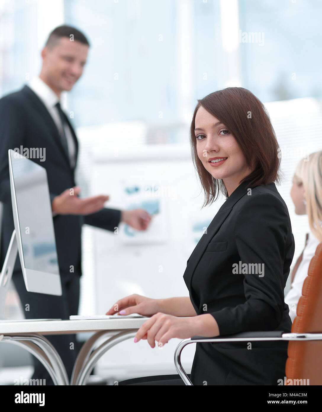 portrait of a successful female assistant sitting at a Desk Stock Photo ...