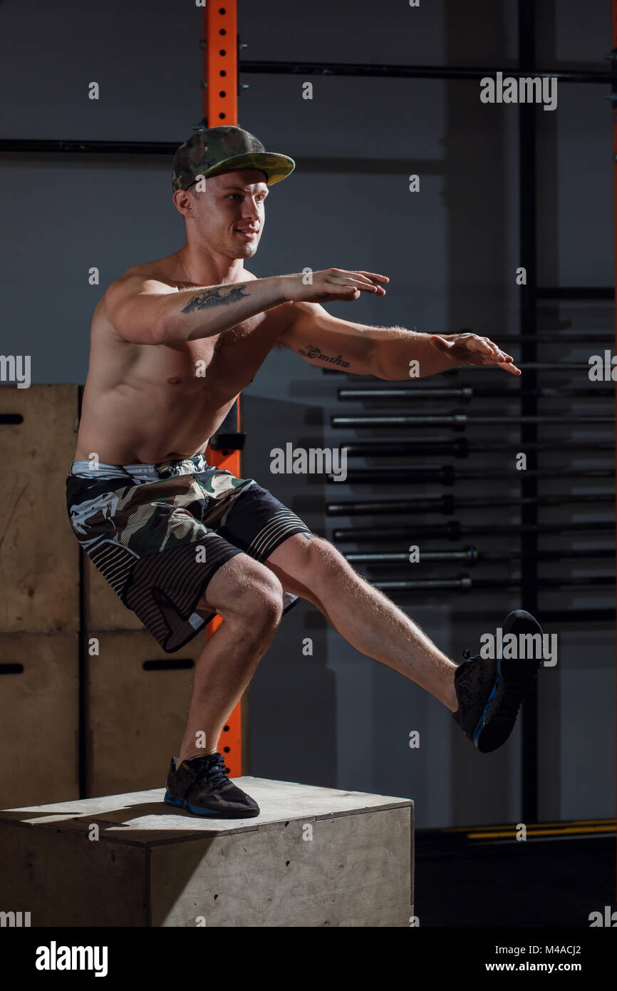 Brutal tattooed calisthenics coach shows exercise moves one leg squat ...