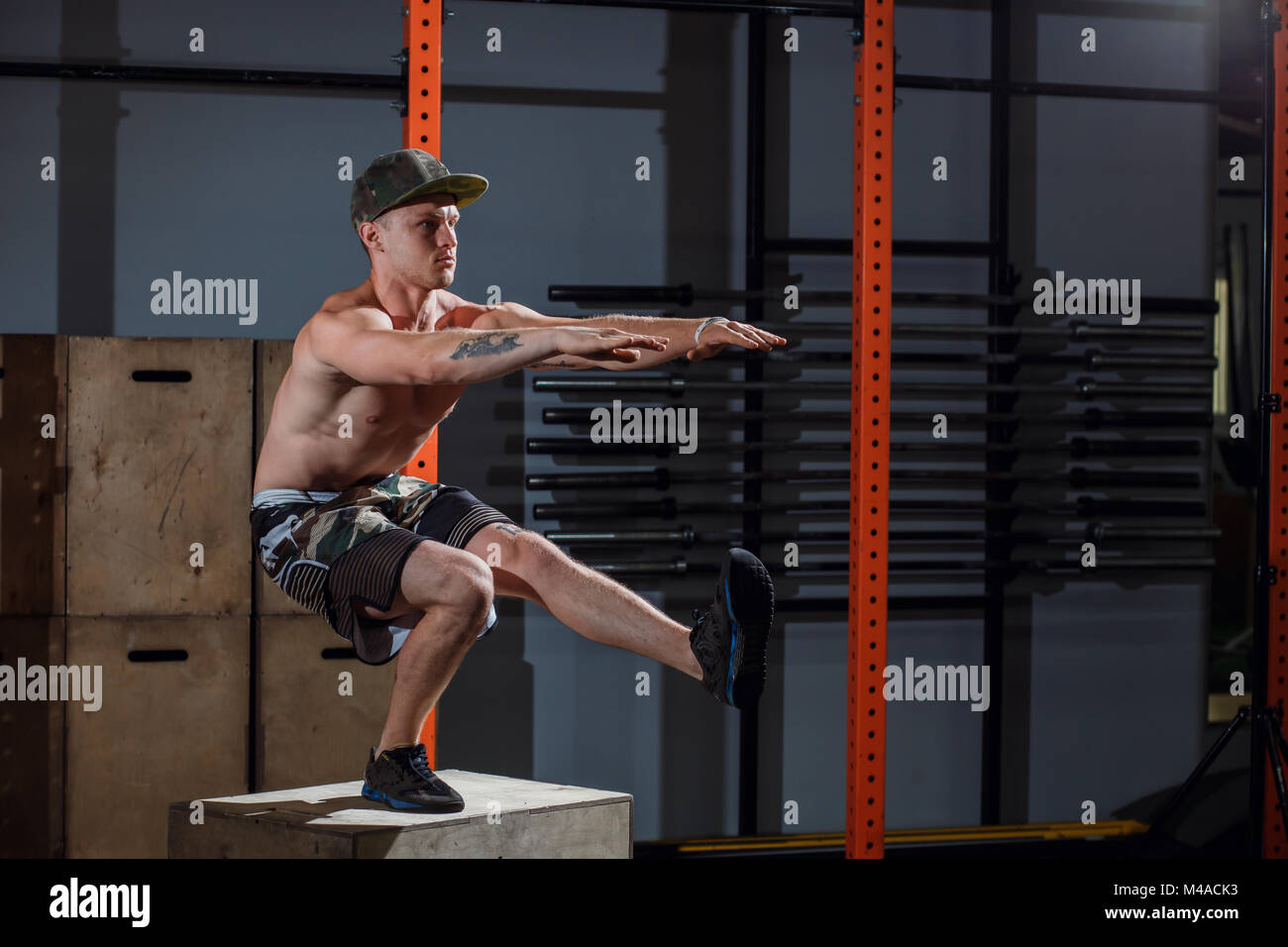 Brutal tattooed calisthenics coach shows exercise moves one leg squat ...